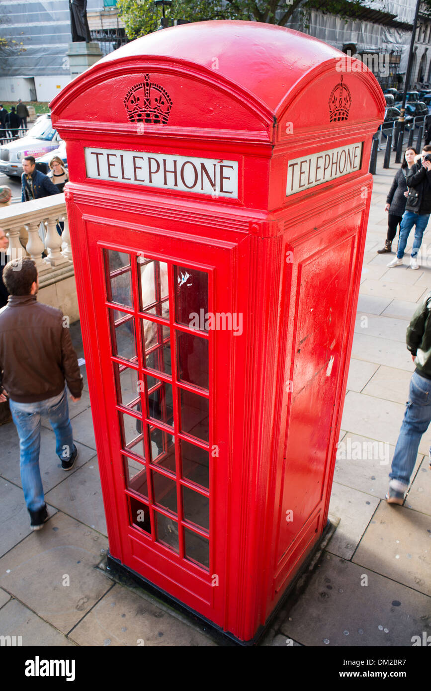 Red english Telephone booth and people around it Stock Photo - Alamy
