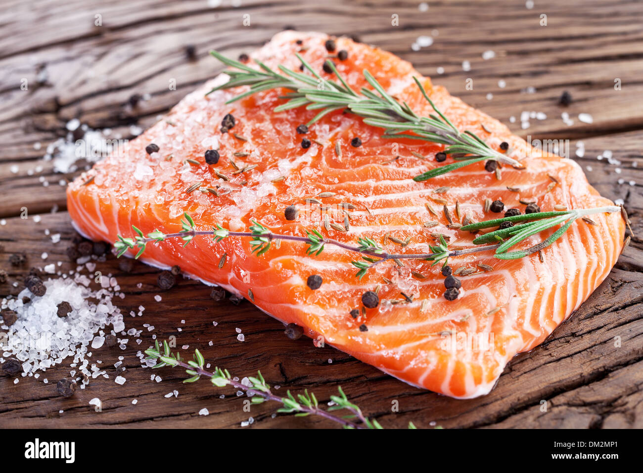 Salmon fillet with spices on a wooden carving board. Macro shot Stock ...