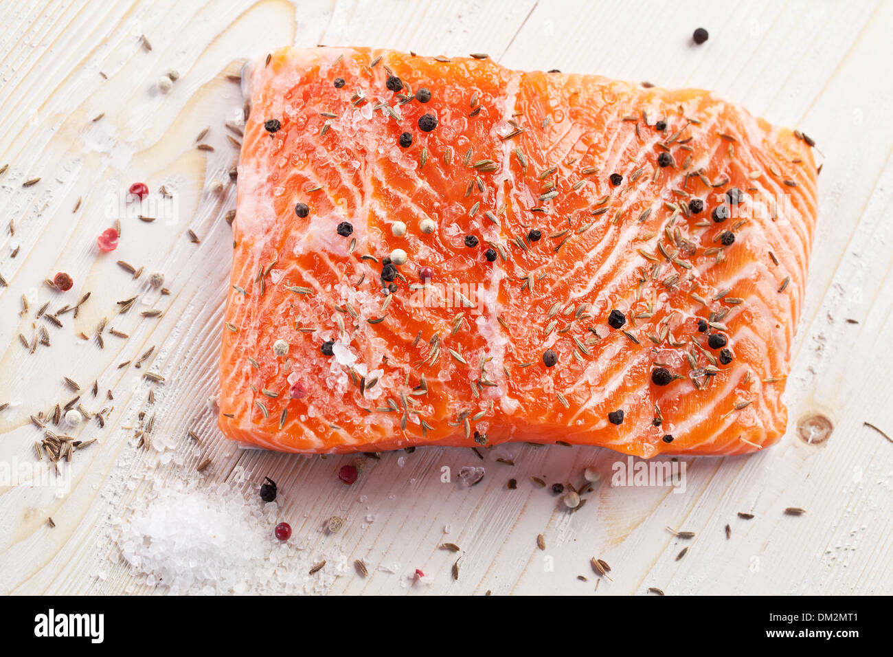 Salmon filet with spices on a wooden carving board. Macro shot Stock ...
