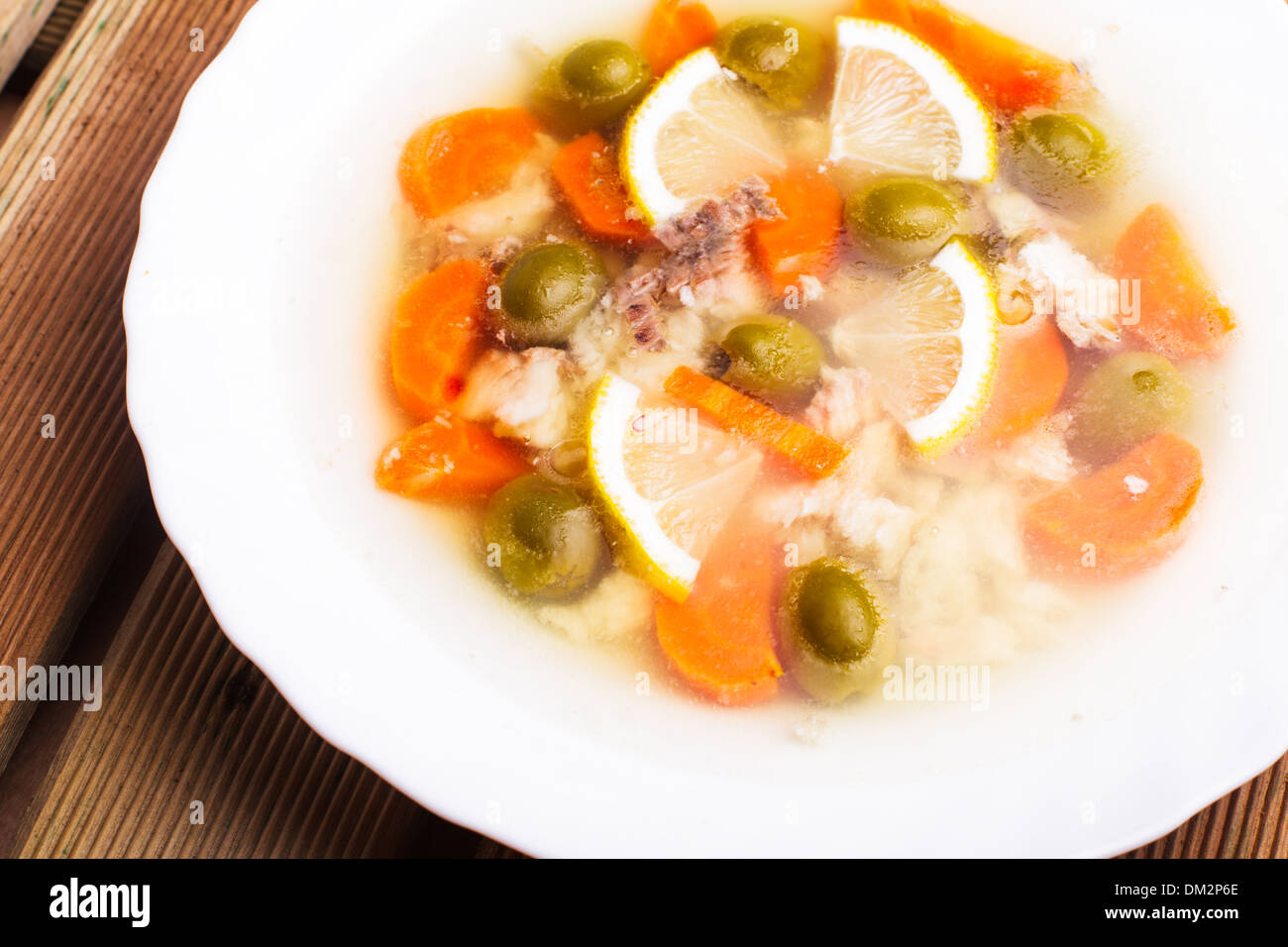 Sturgeon with lemon and carrot slices and green olives in aspic Stock ...
