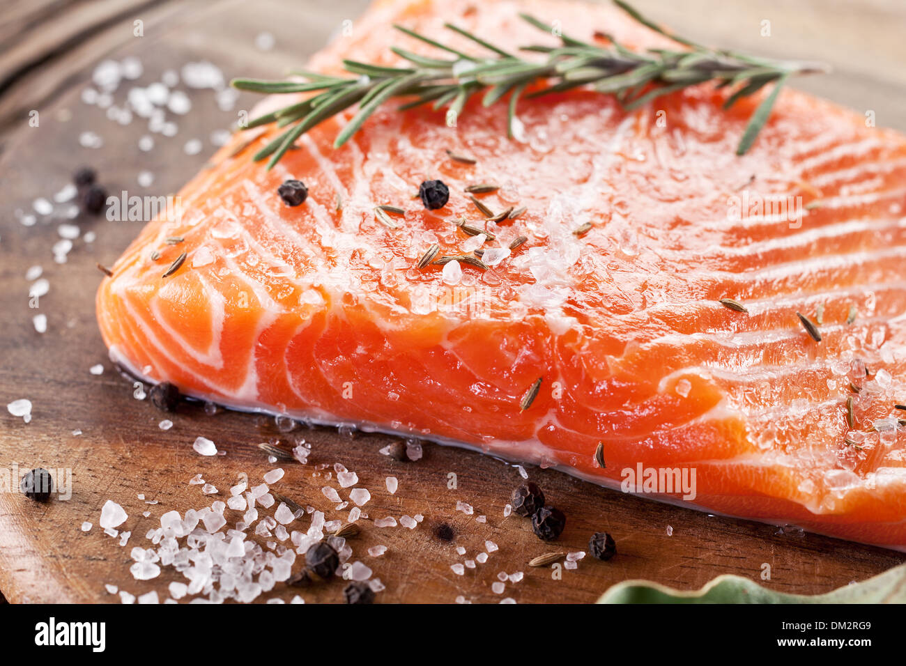 Salmon fillet with spices on a wooden carving board. Macro shot Stock ...