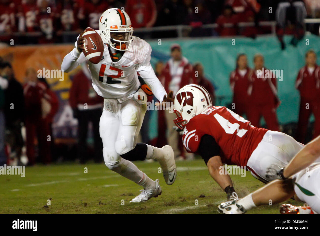 Miami (FL) quarterback Jacory Harris (12) attempts to avoid Wisconsin ...