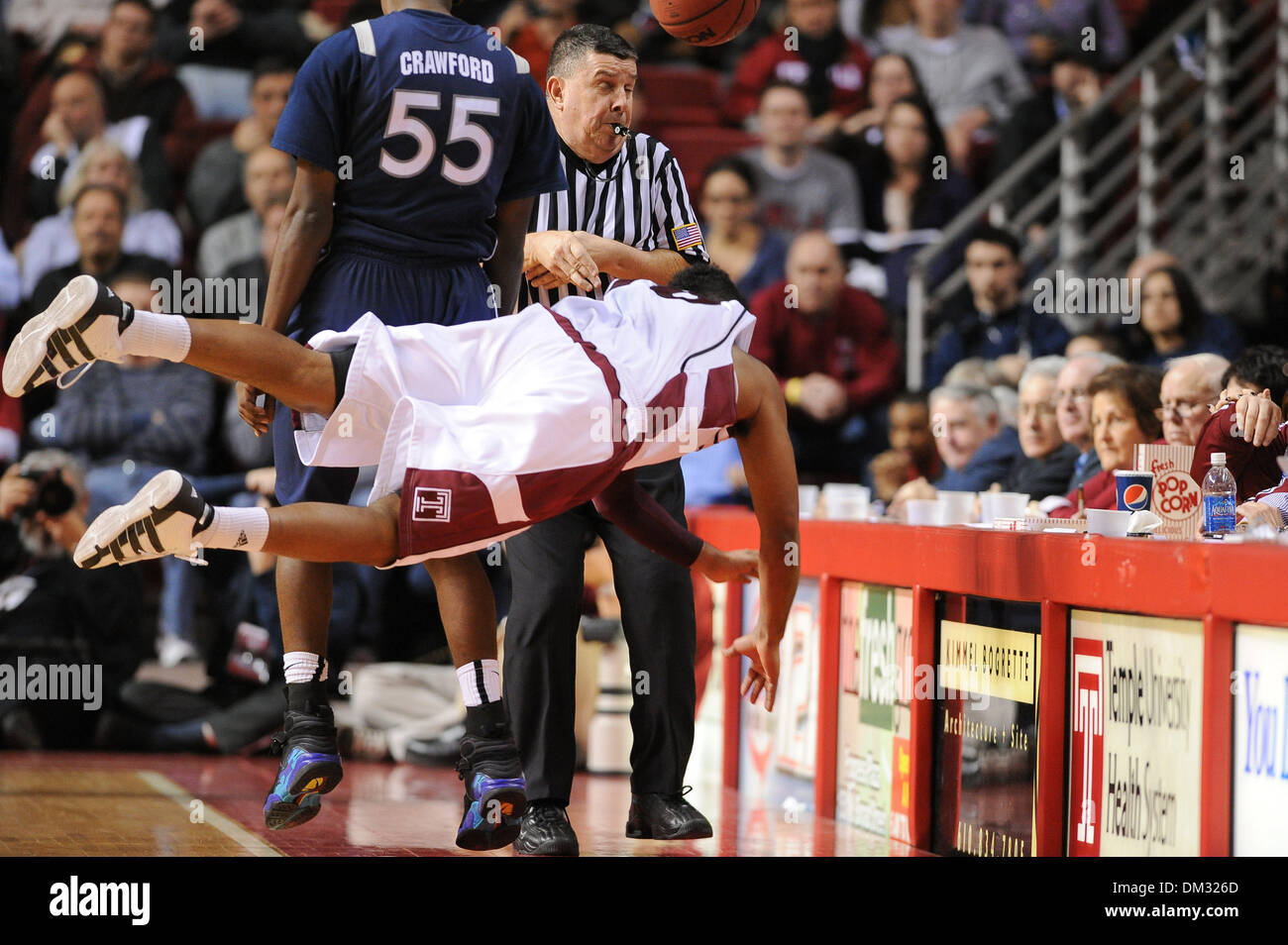 Temple guard Luis Guzman #10 dives into the scorers table chasing a ...