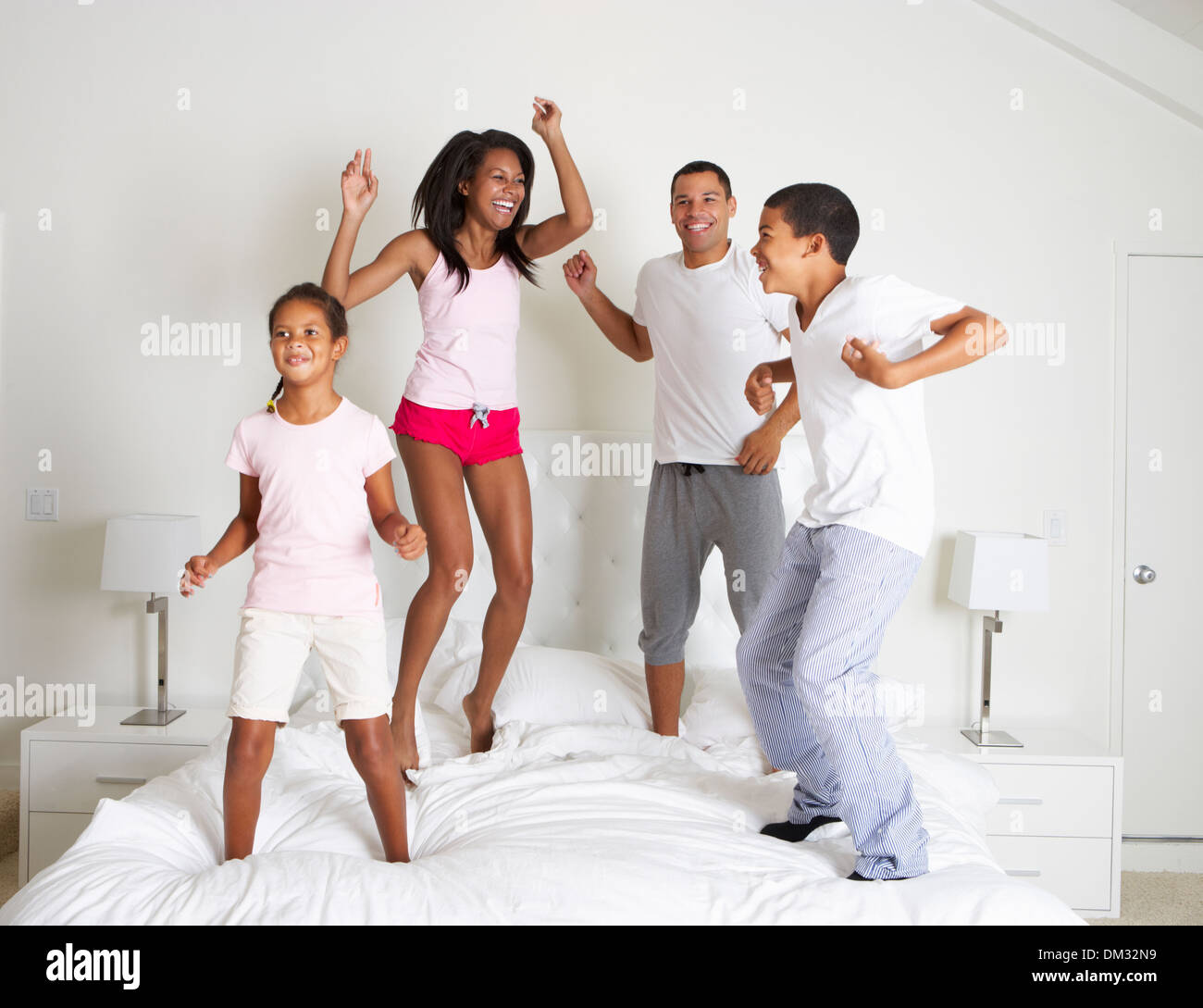 Family Jumping On Bed Together Stock Photo - Alamy