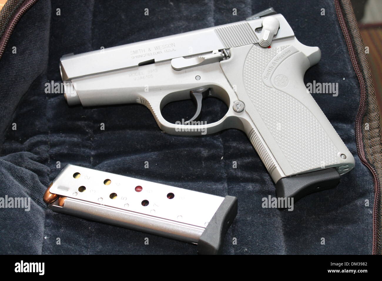 A pistol by Smith & Wesson (model 3913) with magazine lies on a case ...