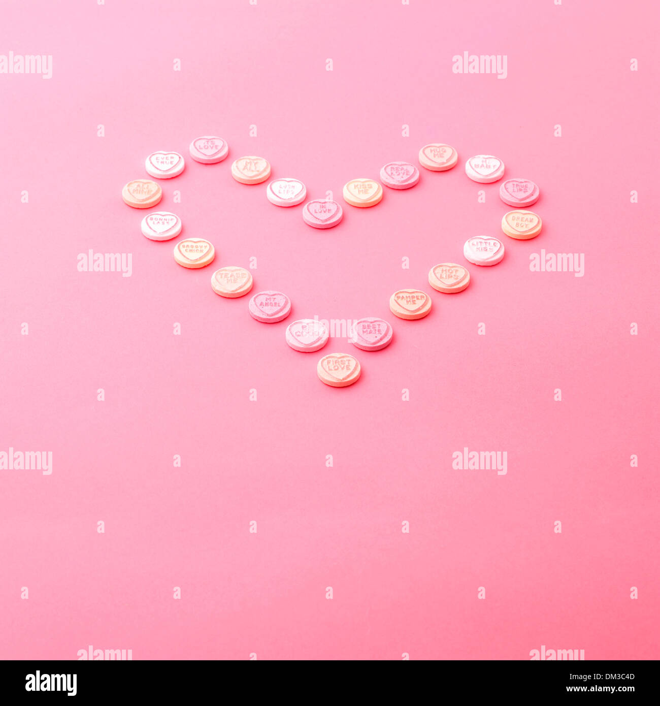 Love heart sweets in a heart shape on a pink background Stock Photo - Alamy