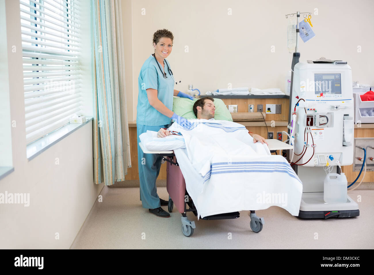 Nurse Standing By Patient Receiving Dialysis In Hospital Stock Photo ...