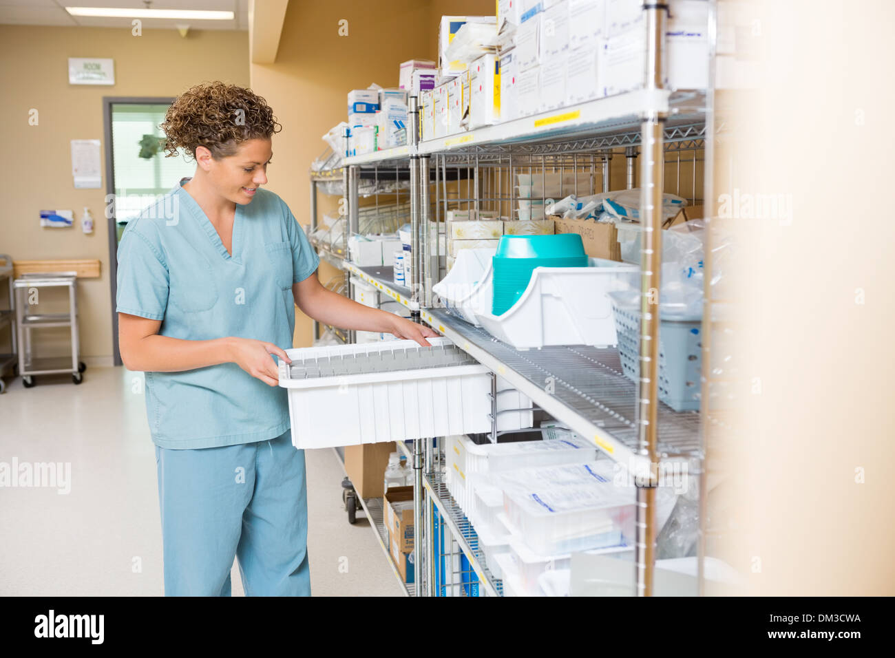 Nurse Arranging Container On Shelf In Storage Room Stock Photo - Alamy