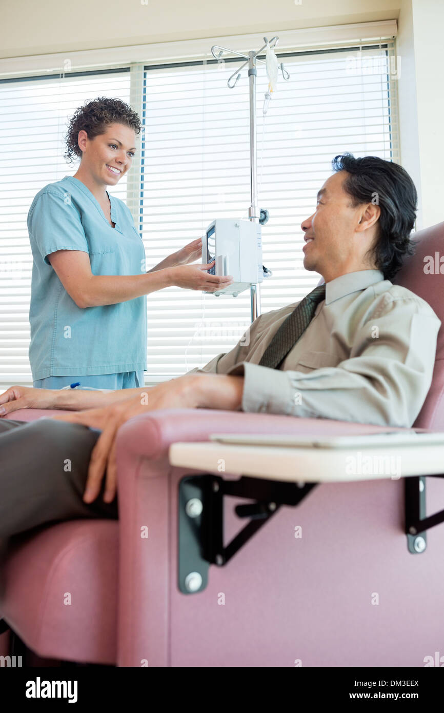 Nurse Looking At Patient While Operating IV Machine Stock Photo - Alamy