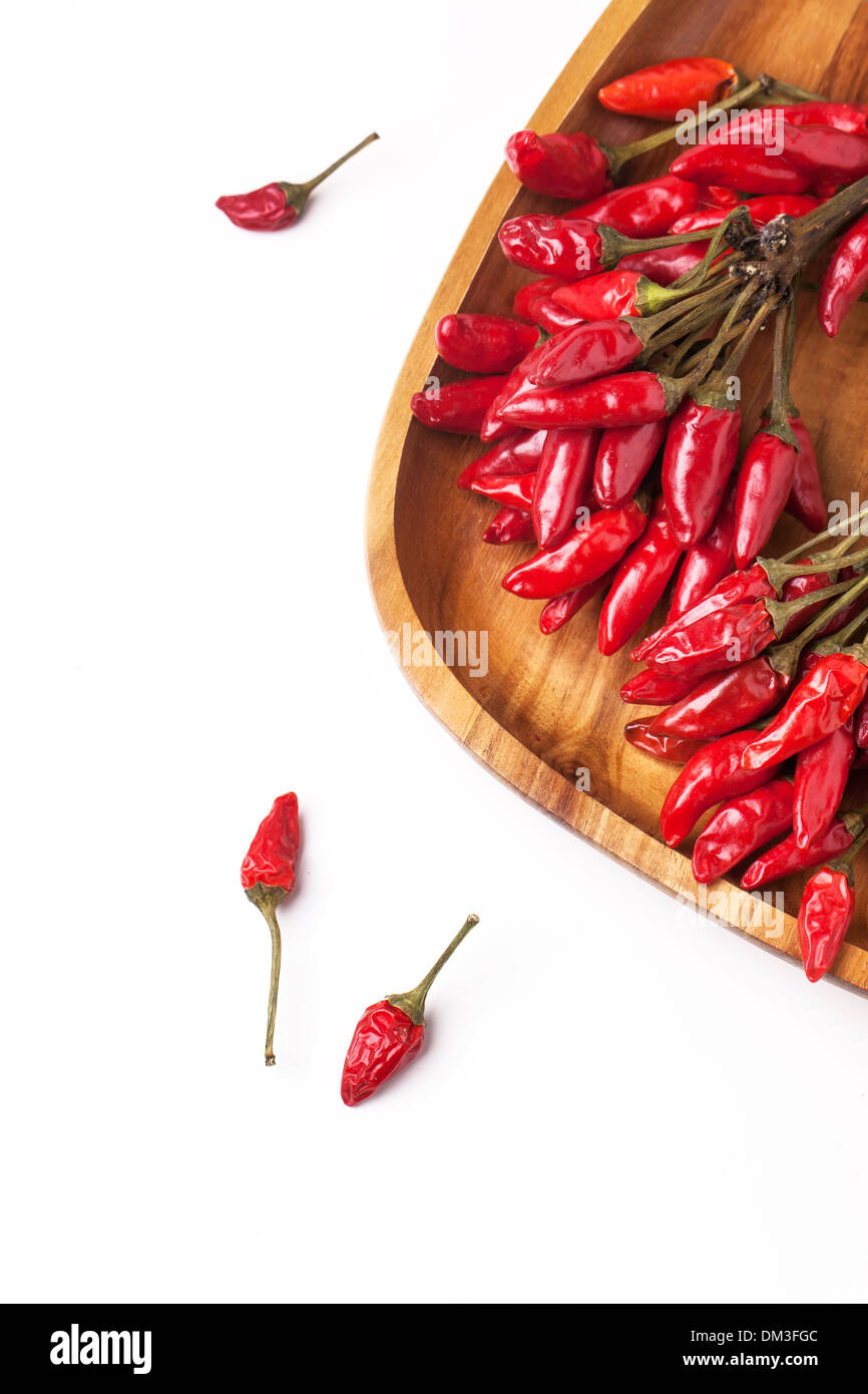 Top view on wooden plate with bundles of red hot chili peppers over ...