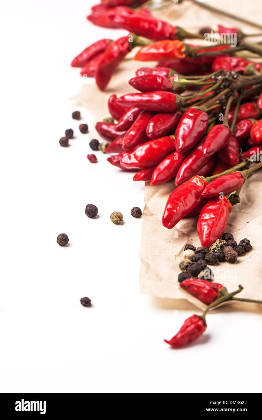 Bundles of red hot chili peppers with peppercorns on crumpled paper ...