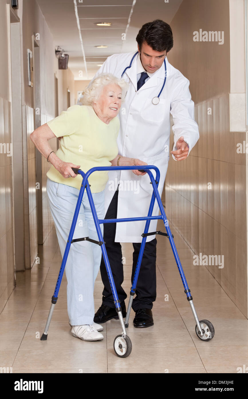 Doctor helping Patient use Walker Stock Photo - Alamy