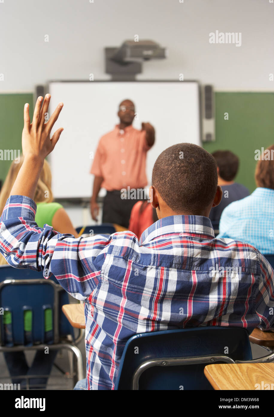 Male Pupil Raising Hand In Class Stock Photo - Alamy