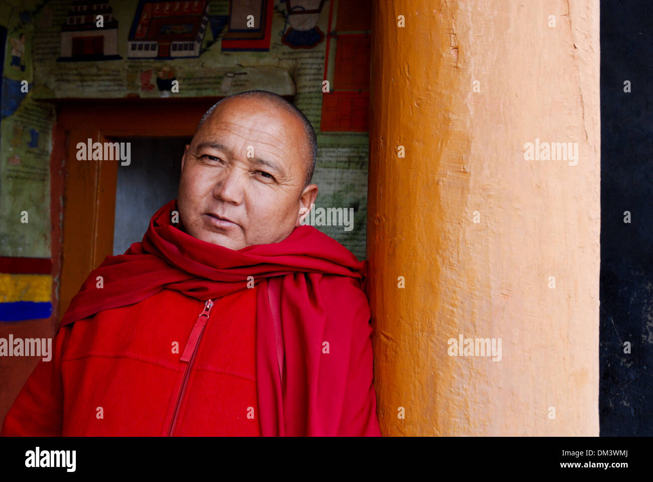 Ladakh, India - 14 July 2009: a buddhist monk in a red rope leans on a ...