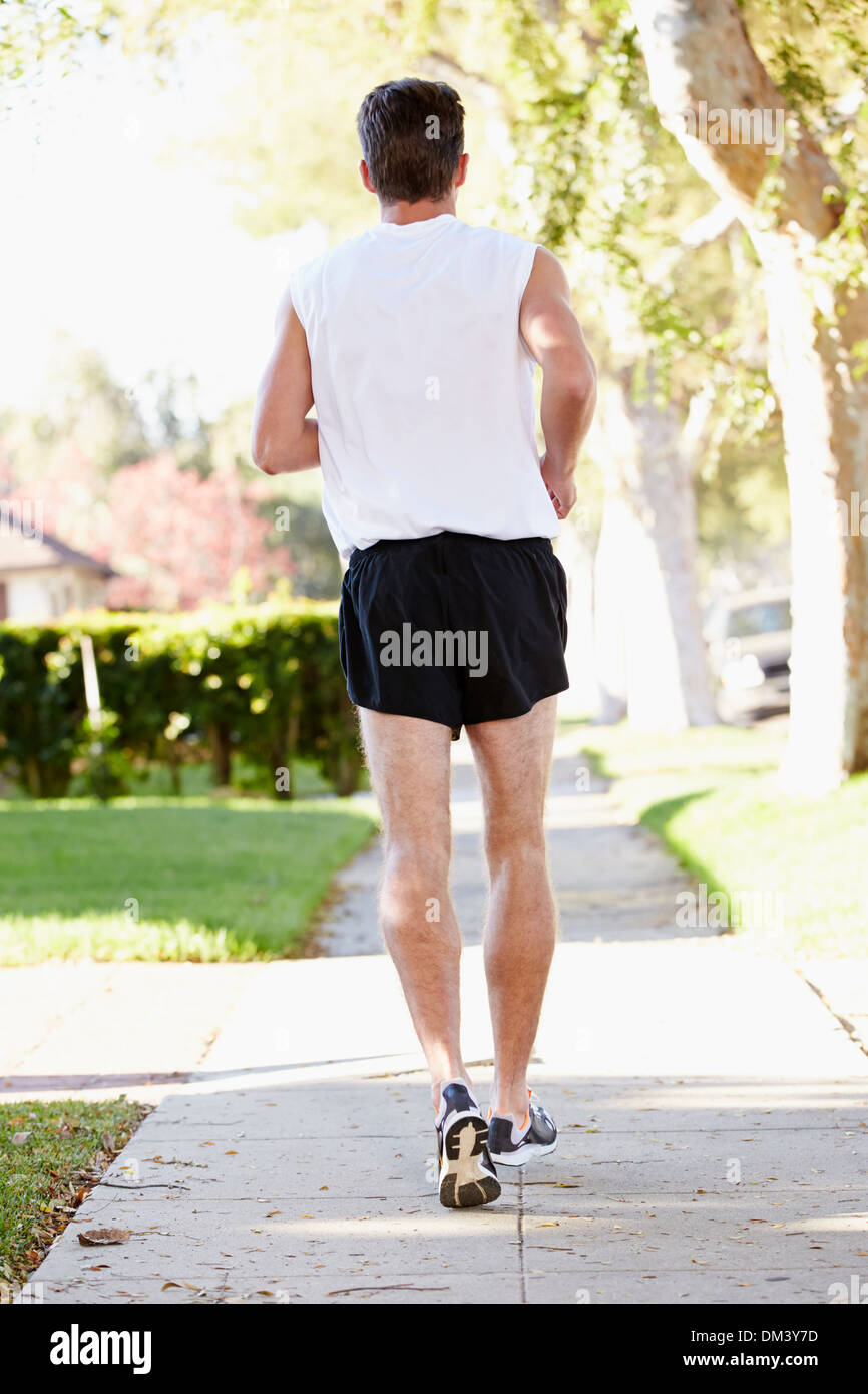 Rear View Of Male Runner Exercising On Suburban Street Stock Photo - Alamy