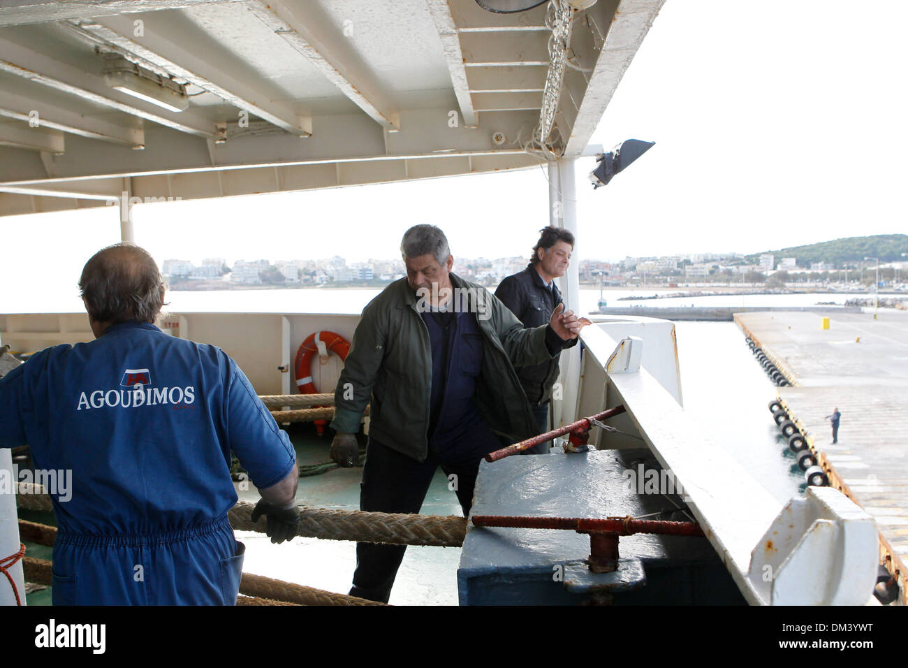 Ship crew guiding heavy duty mooring rope during docking procedure ...
