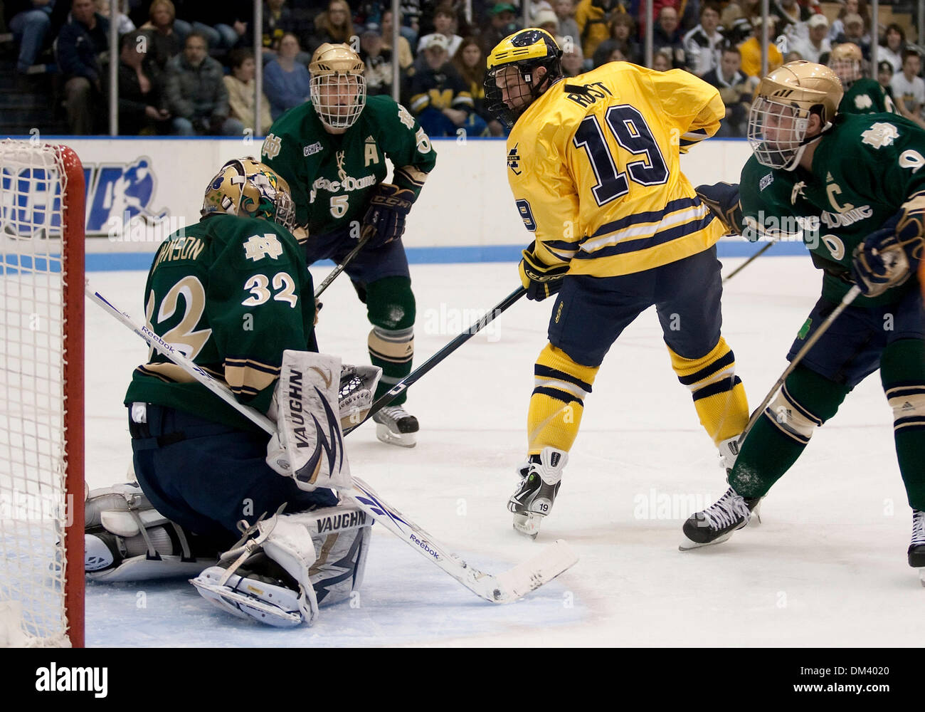 Michigan Center Matt Rust (19) and Notre Dame Goalie Mike Johnson (32 ...