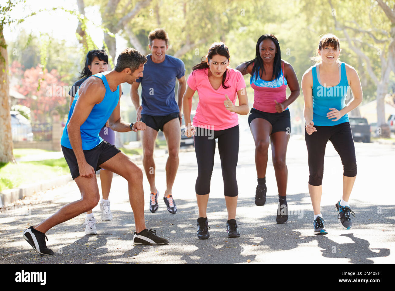 Group Of People Exercising Street With Personal Trainer Stock Photo - Alamy