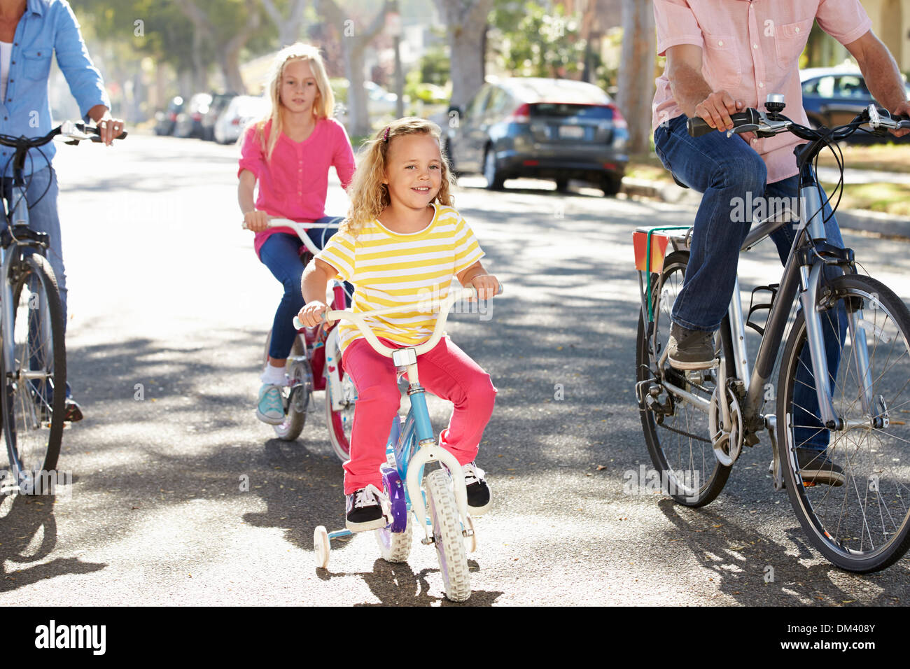 Family Cycling On Suburban Street Stock Photo - Alamy