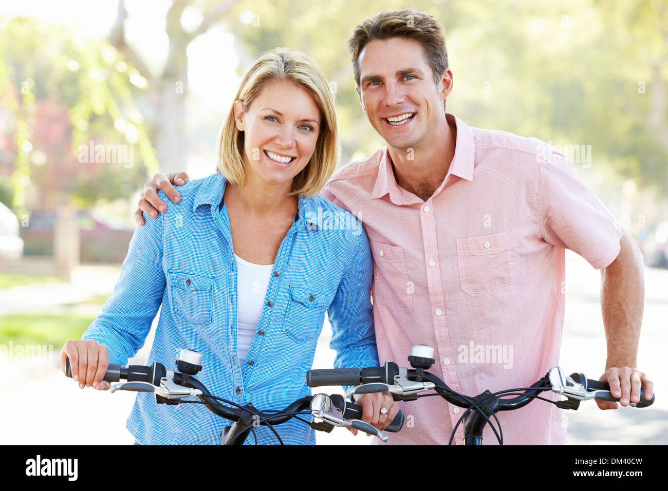 Couple Cycling On Suburban Street Stock Photo - Alamy