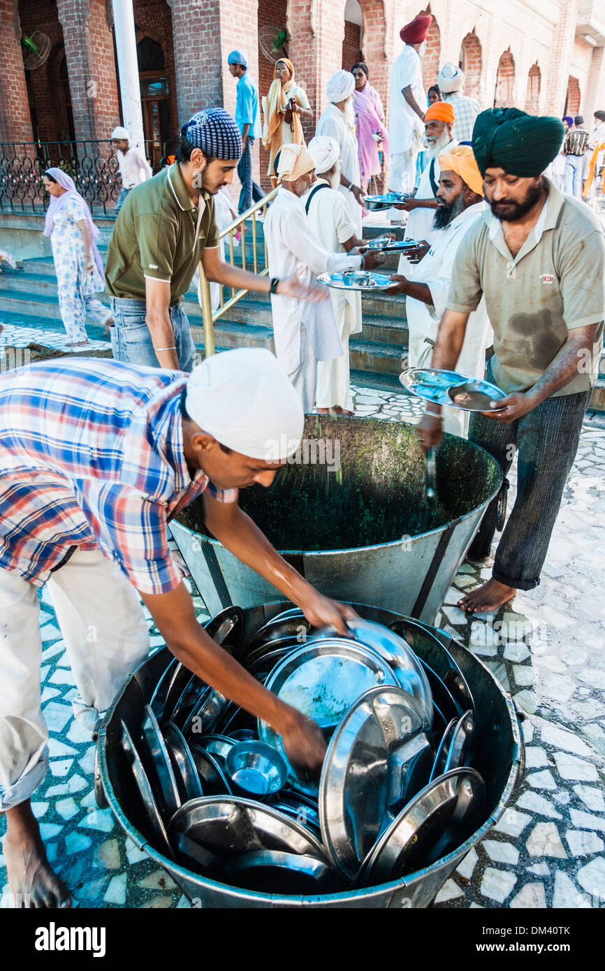 Sikh volunteers washing dishes at the Golden Temple in Amritsar, India ...