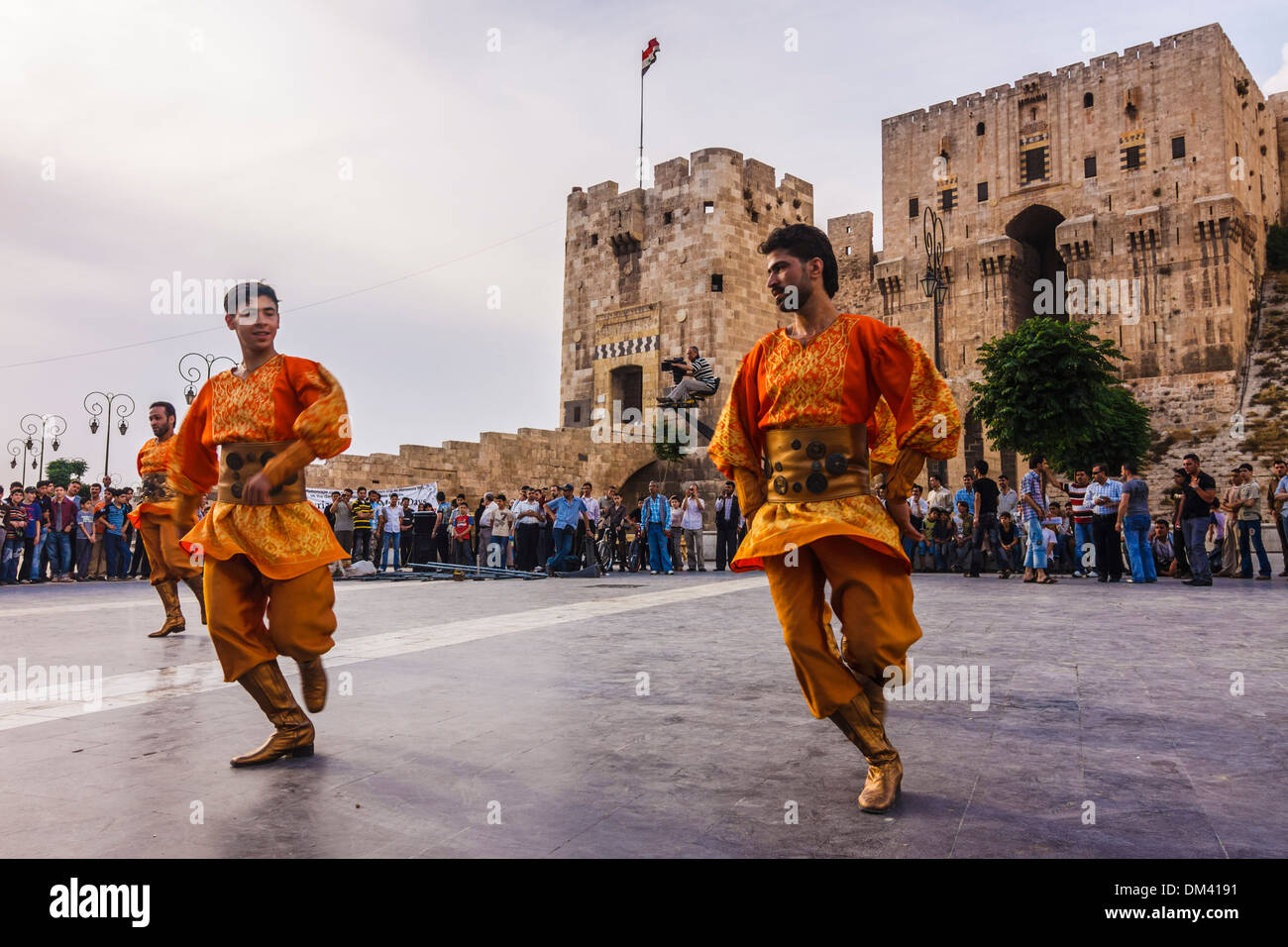 Dancers in traditional costumes performing by the citadel of Aleppo ...