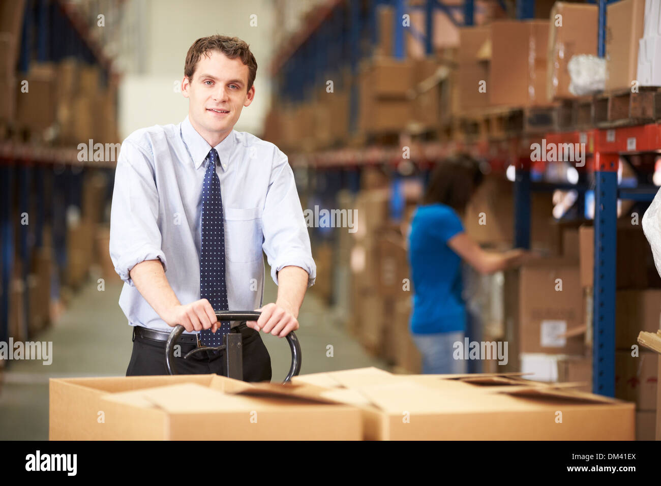 Businessman Pulling Pallet In Warehouse Stock Photo - Alamy