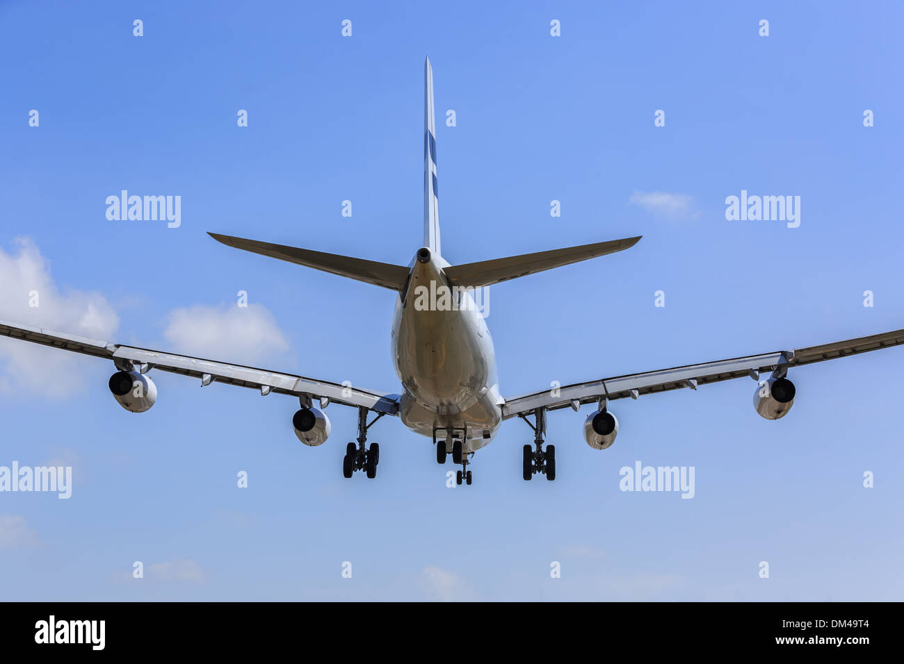 airplane landing in bright Blue sky, right before touch-down. Rear View ...
