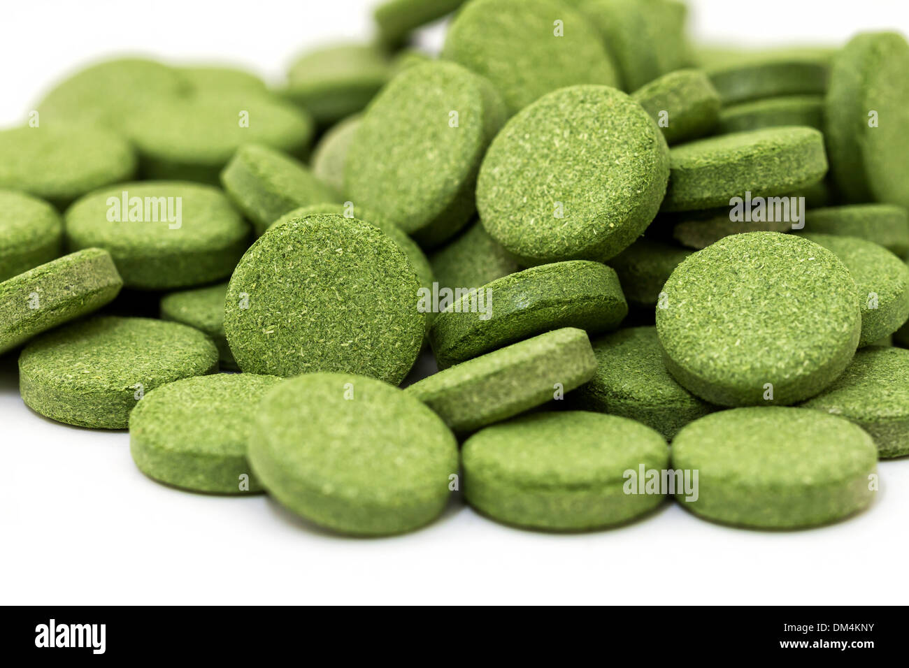 Green chlorophyll tablets on white background Stock Photo - Alamy