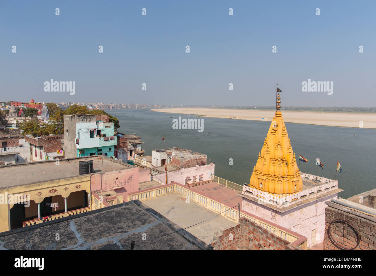 A temple spire stands among rooftops overlooking the Ganges River in ...