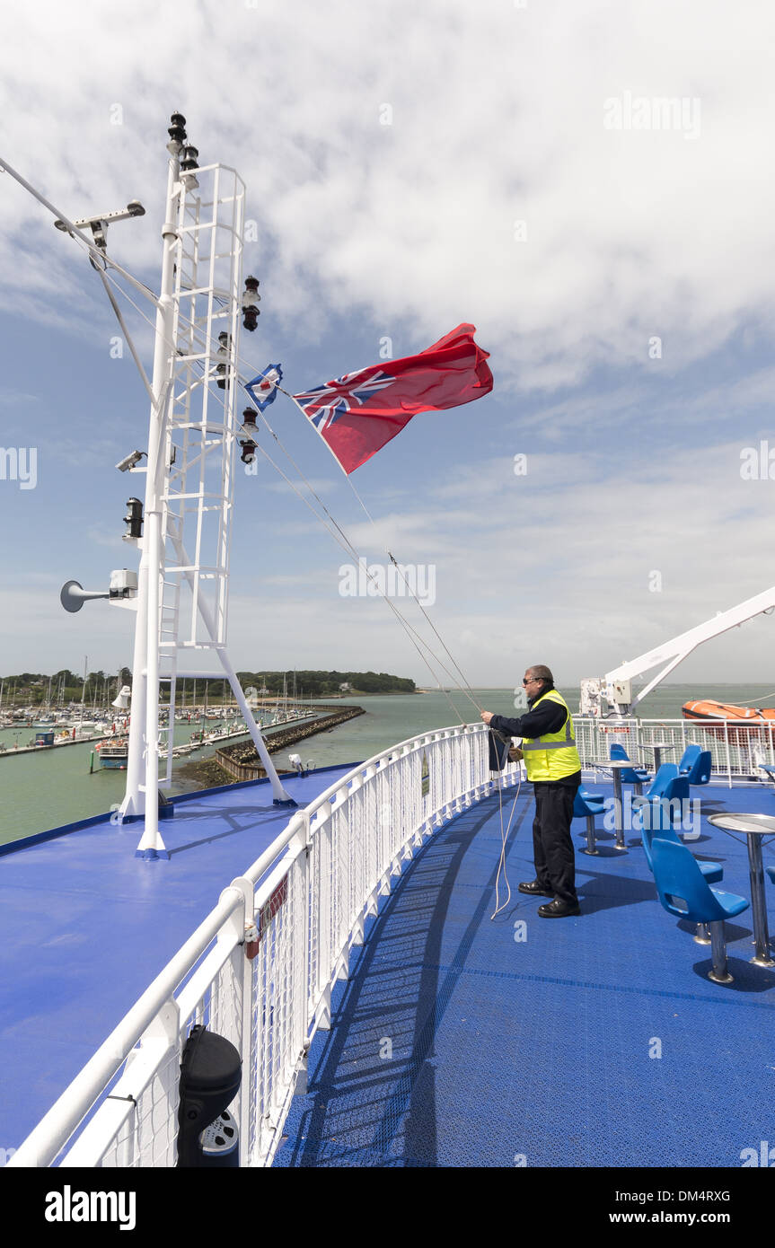 The raising of the Red Ensign flag on the Wightlink ferry approaching ...