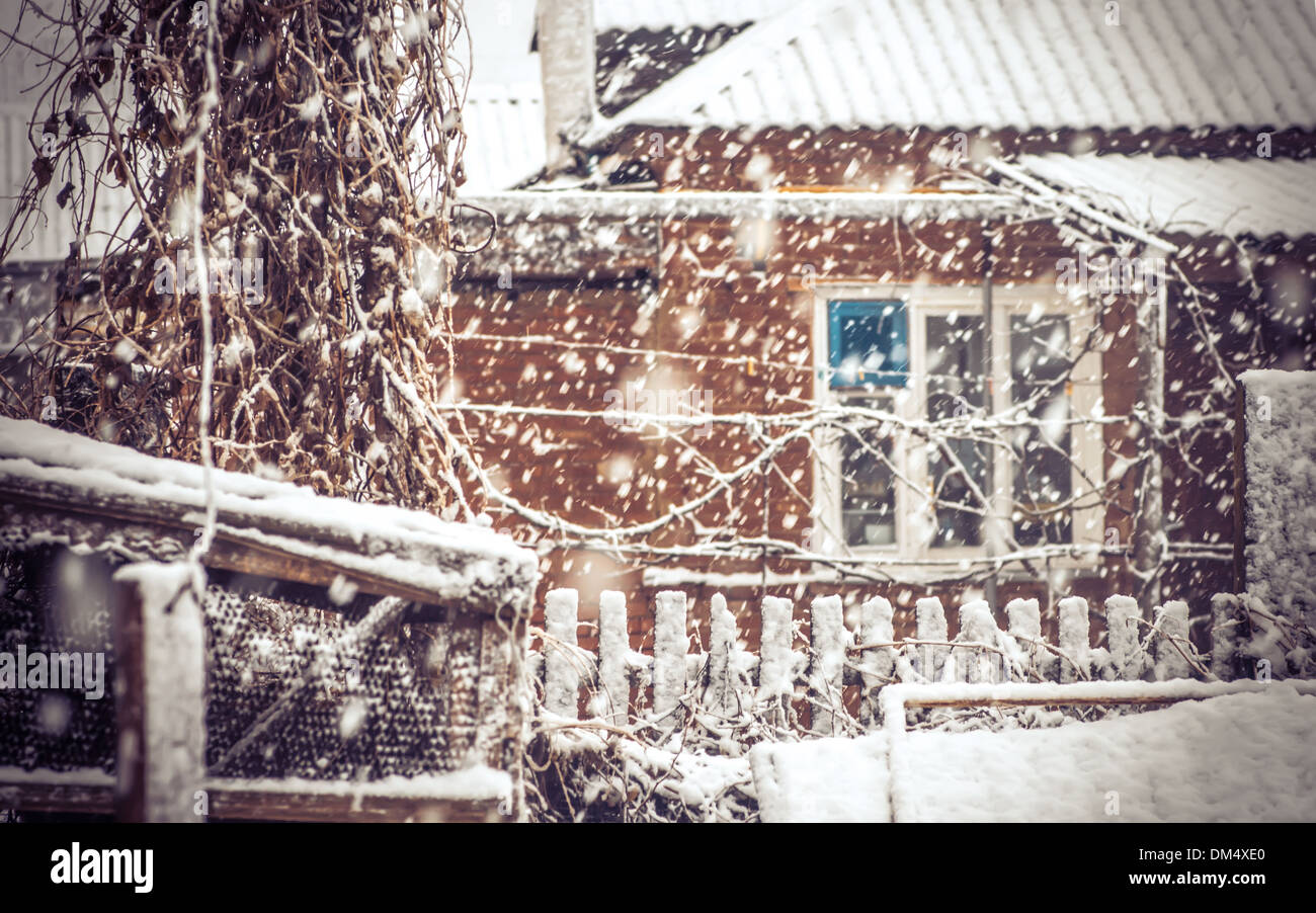 Snowfall Winter Weather in village with snowflakes and old house window ...