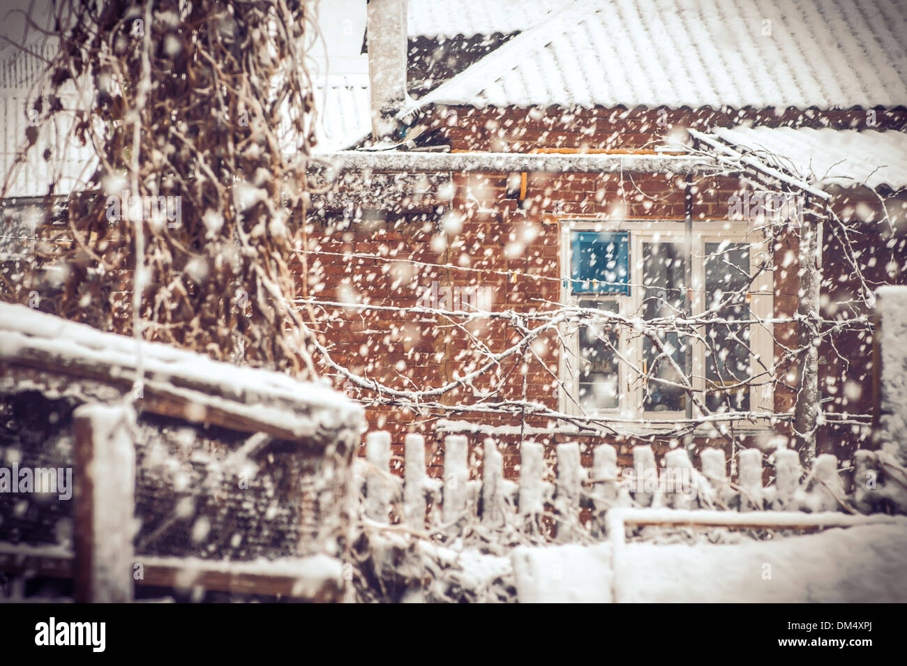 Snowfall Winter Weather in village with snowflakes and old house window ...