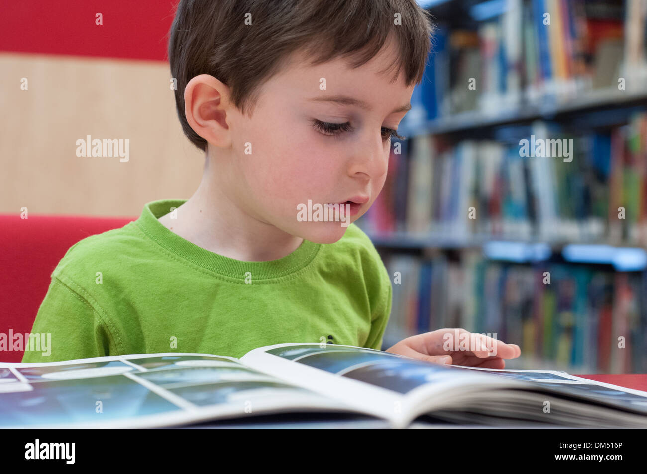 Child reading at public library Stock Photo - Alamy