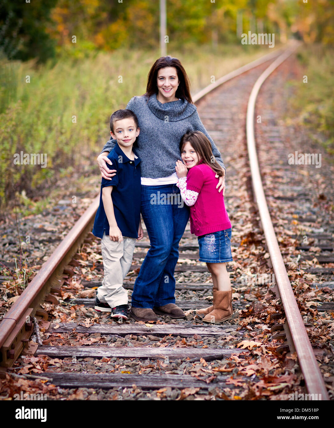 Beautiful mother and her children on train tracks Stock Photo - Alamy