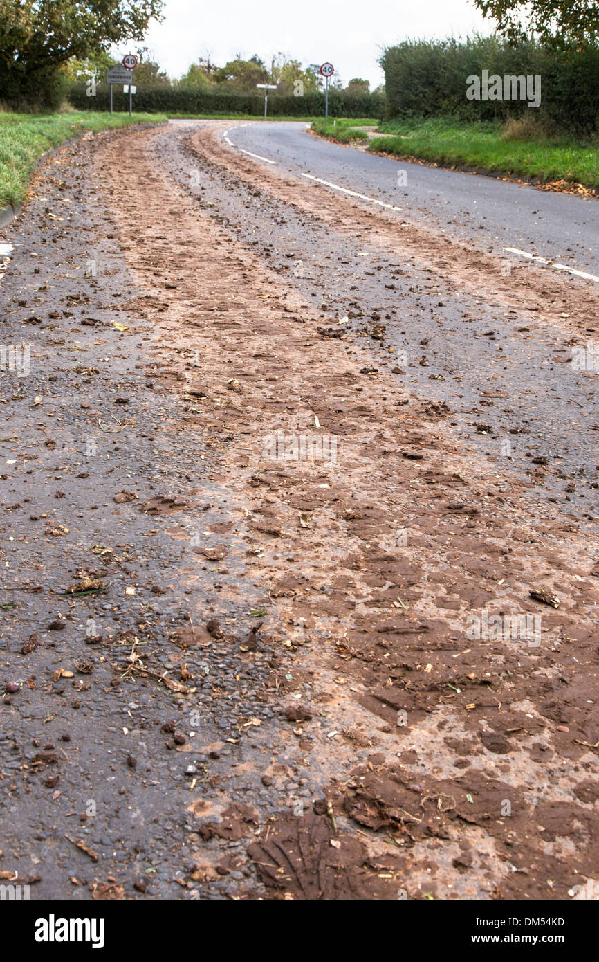 Mud on country lane from farm machinery moving harvester crops, England ...