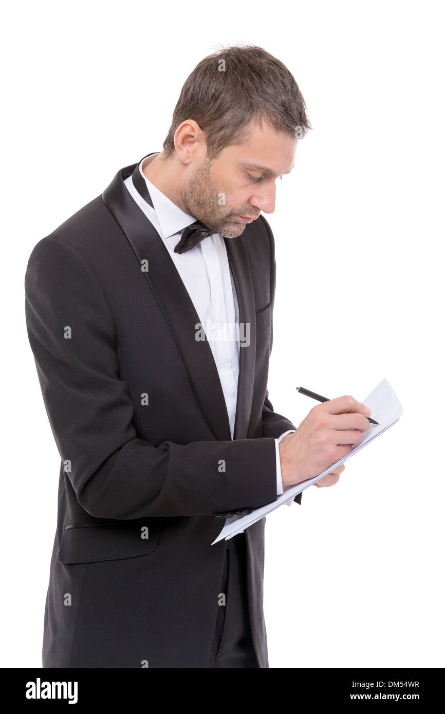 Handsome man in a bow tie and elegant suit standing writing notes ...