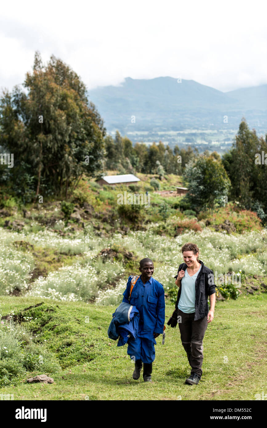 Tourist trekking with local guide Volcanoes National Park Rwanda Africa ...