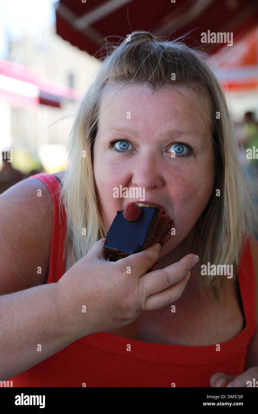 Overweight woman eating chocolate cake Stock Photo - Alamy