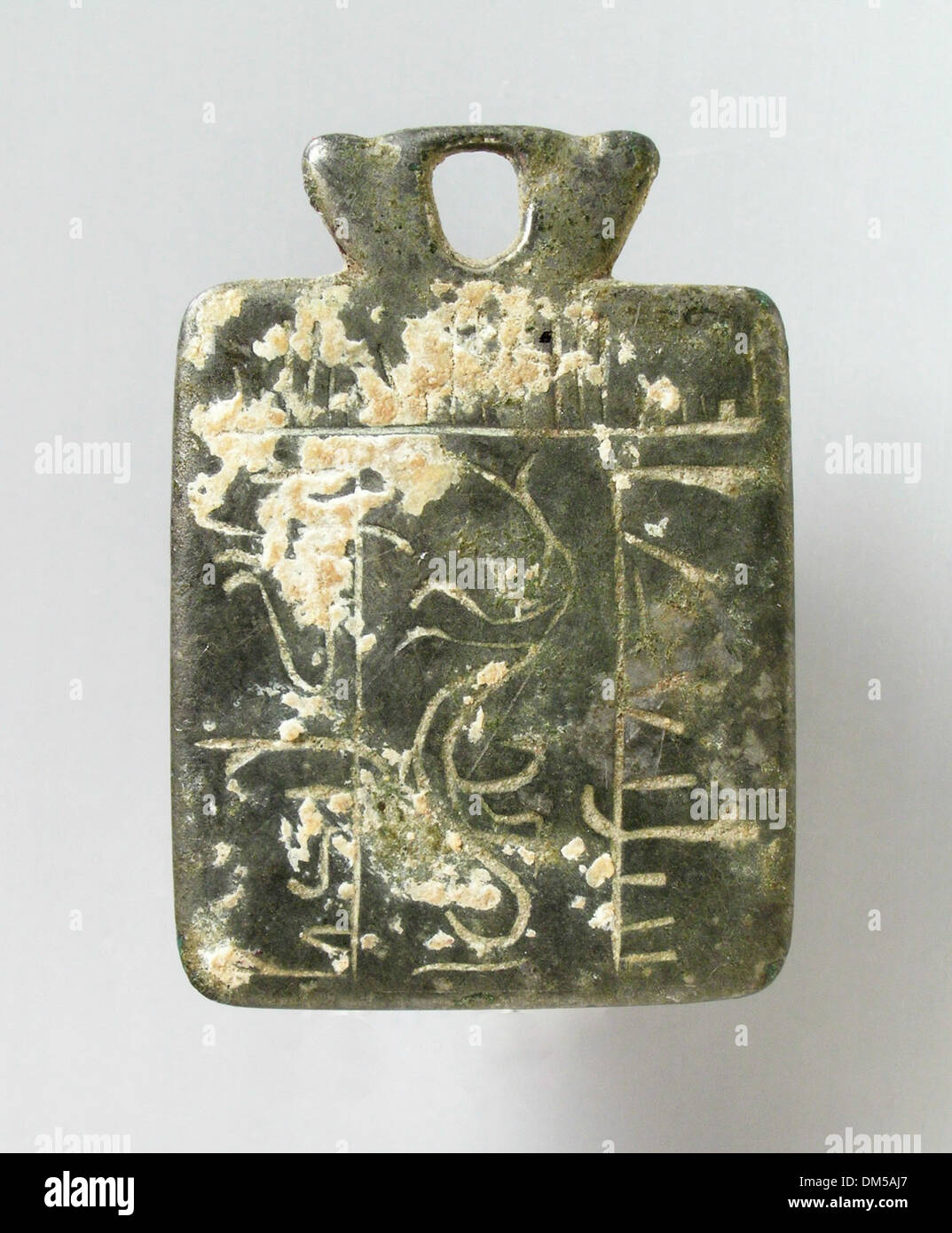 This metal amulet features symbolic motifs, often associated with ...