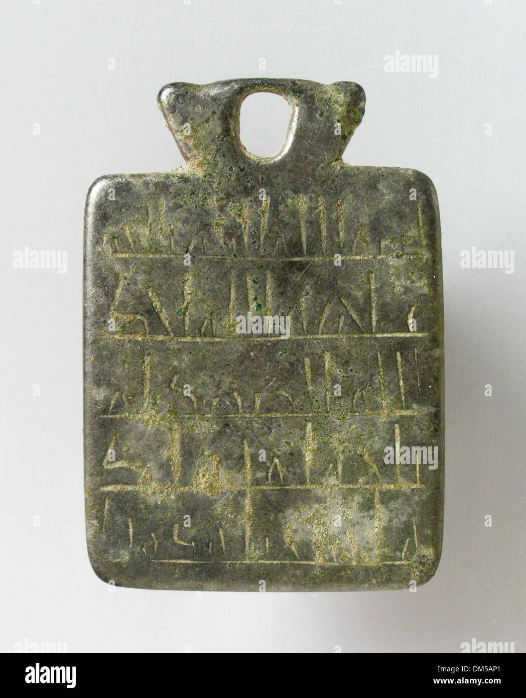 This amulet, crafted from metal, features symbolic motifs that reflect ...