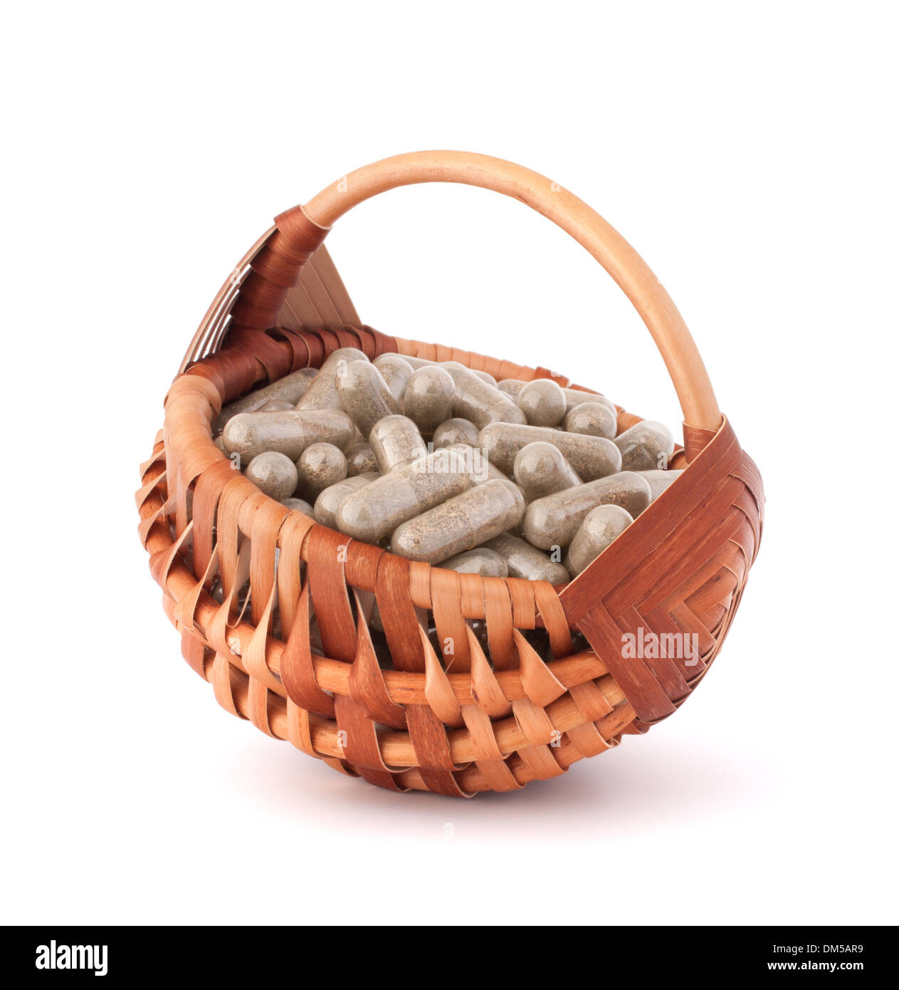 Herbal drug capsules in wicker basket isolated on white background ...
