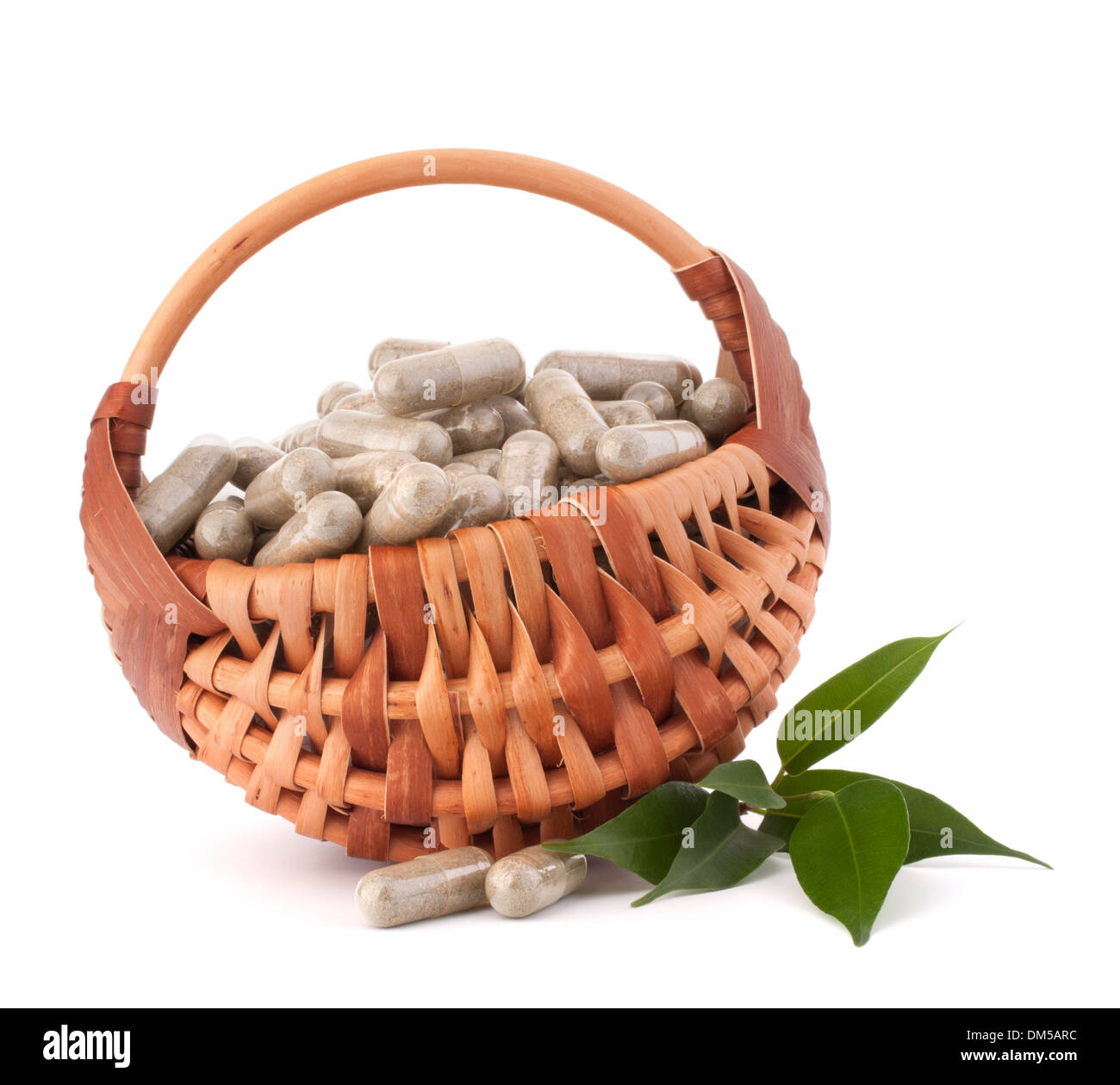 Herbal drug capsules in wicker basket isolated on white background ...