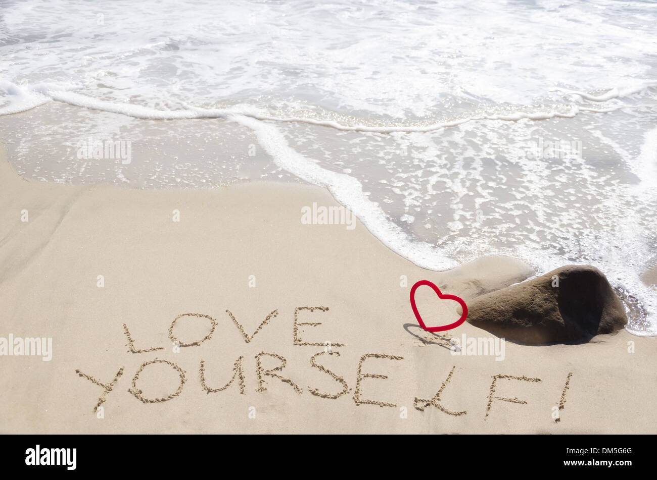 Sign "Love yourself" with heart on the sandy beach by the ocean Stock ...