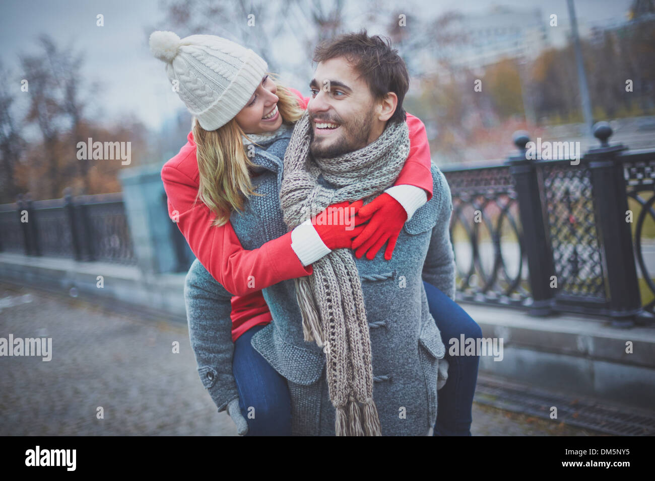Image of affectionate girl on her boyfriend back in park Stock Photo ...