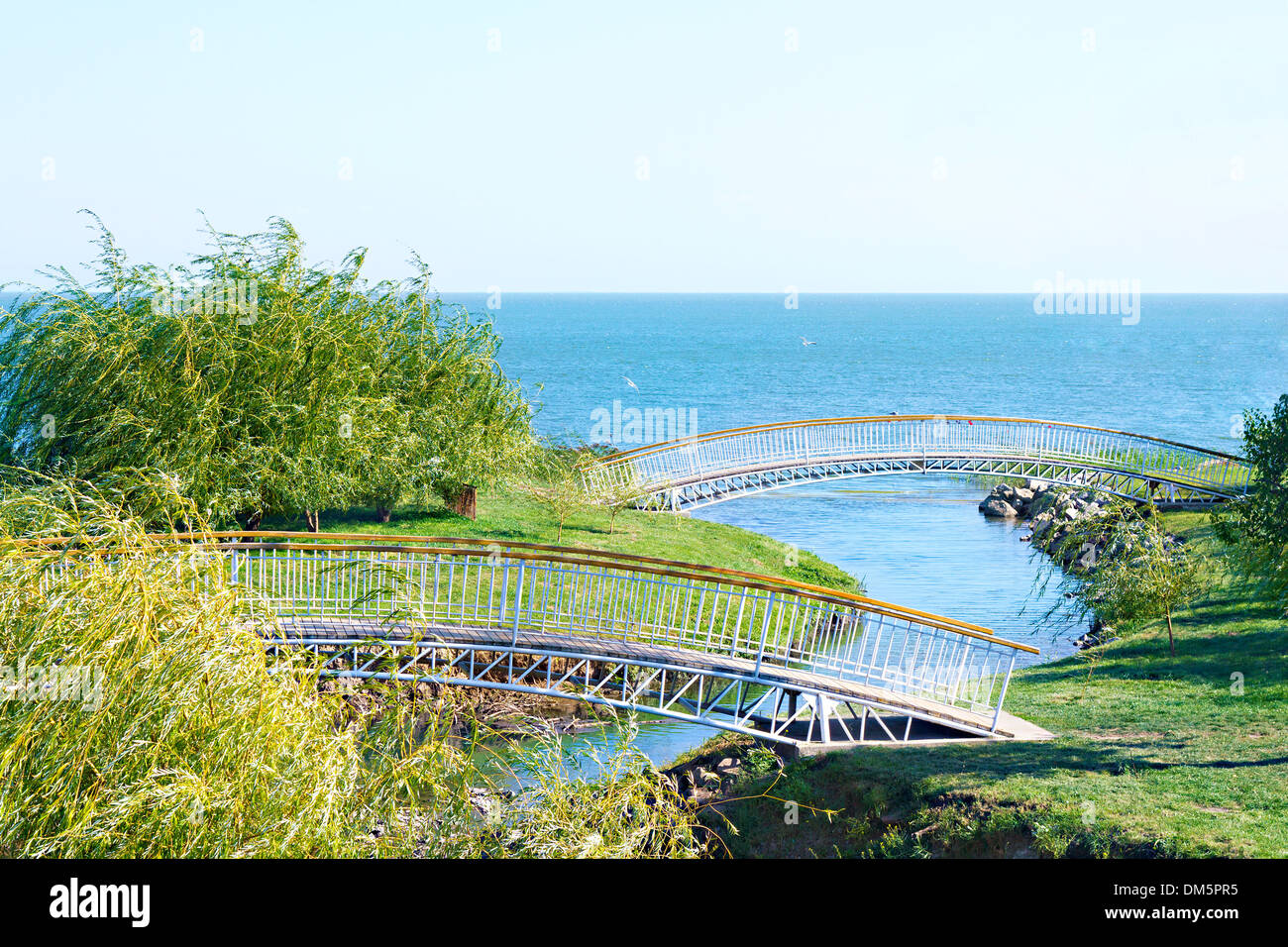 Pedestrian bridges across the river which flows into the sea Stock ...