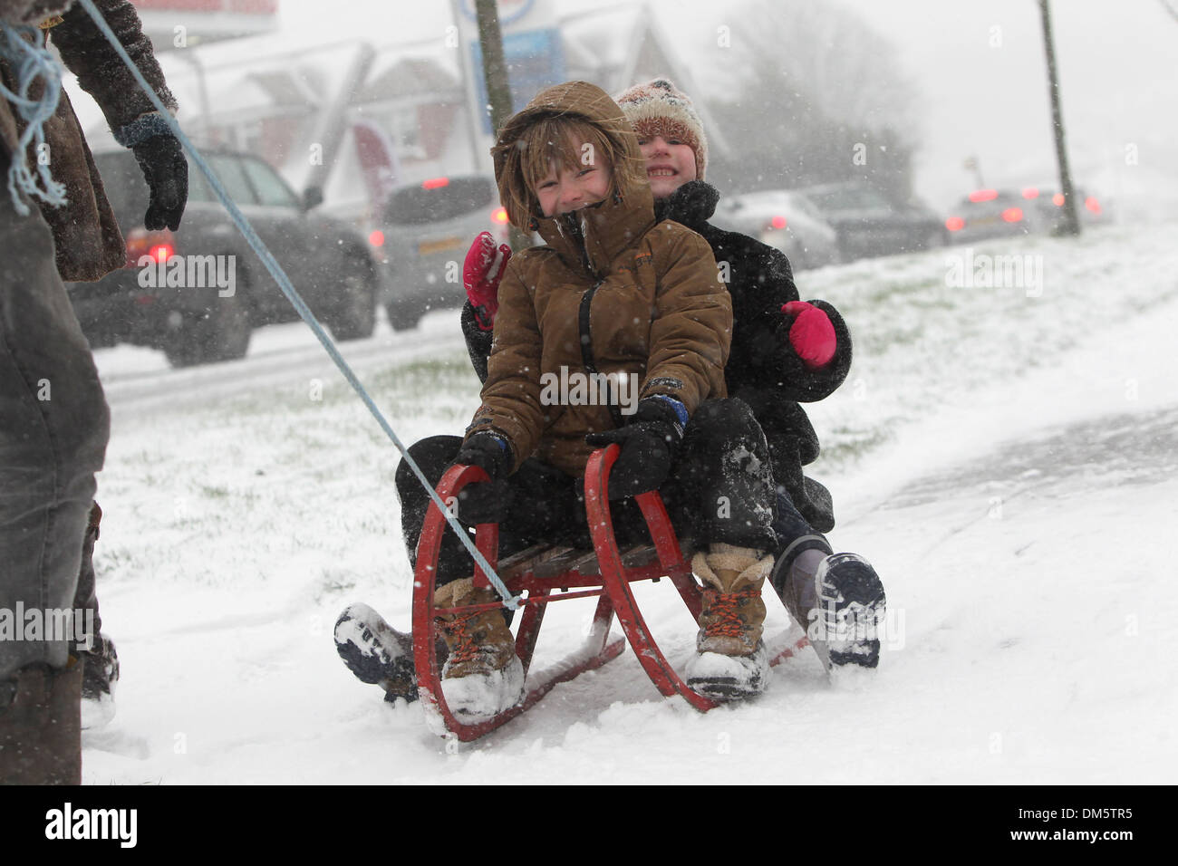 Two children pictured being pulled on a sledge in heavy snow in ...
