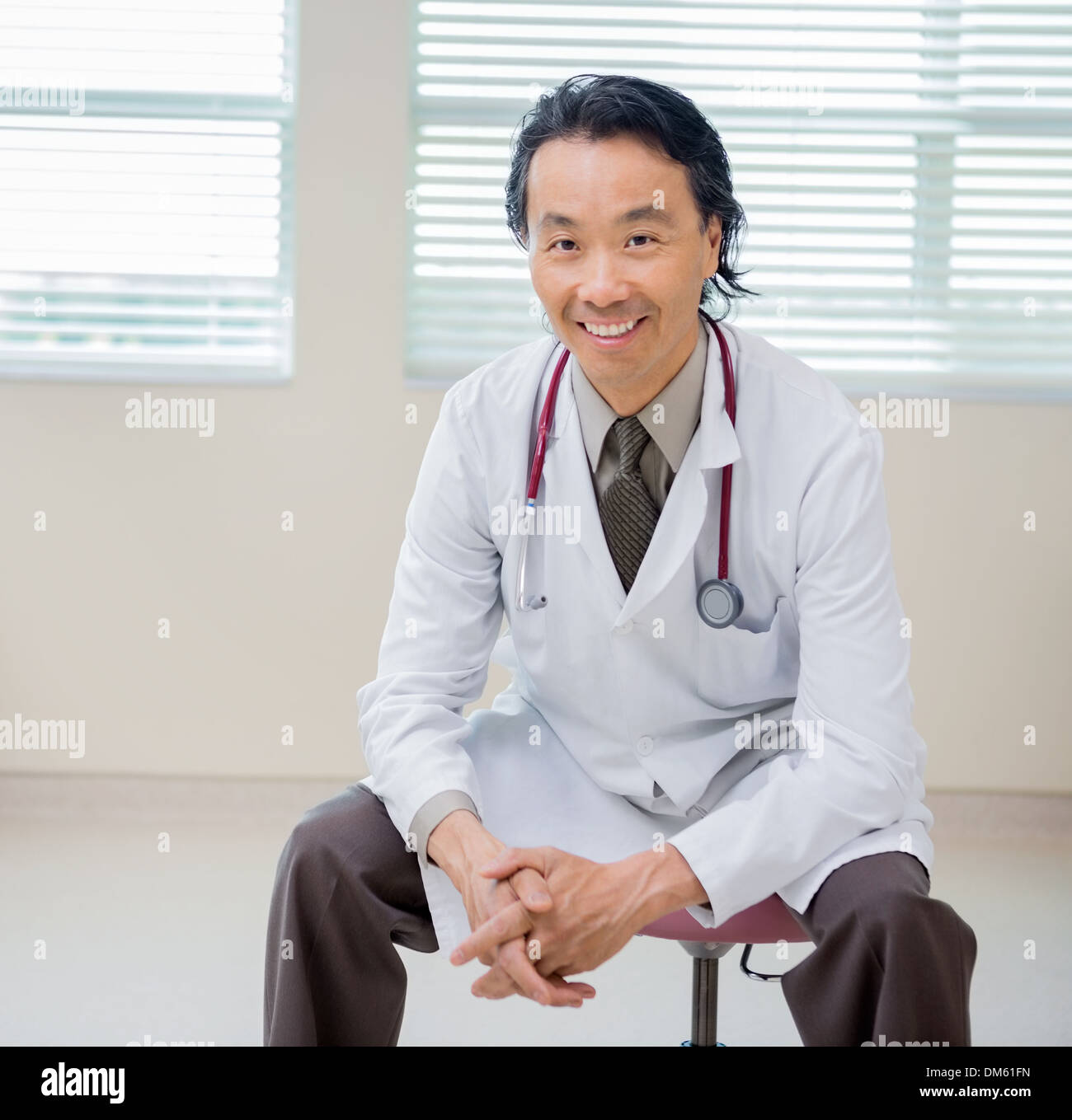 Portrait Of Happy Doctor Sitting In Hospital Room Stock Photo - Alamy