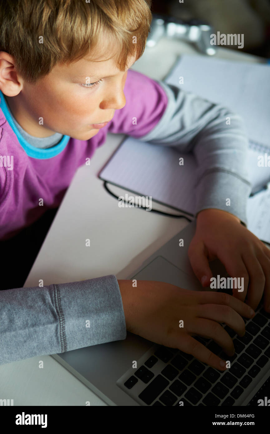 Boy Studying In Bedroom Using Laptop Stock Photo - Alamy