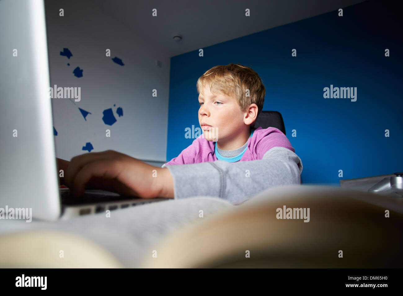 Boy Studying In Bedroom Using Laptop Stock Photo - Alamy